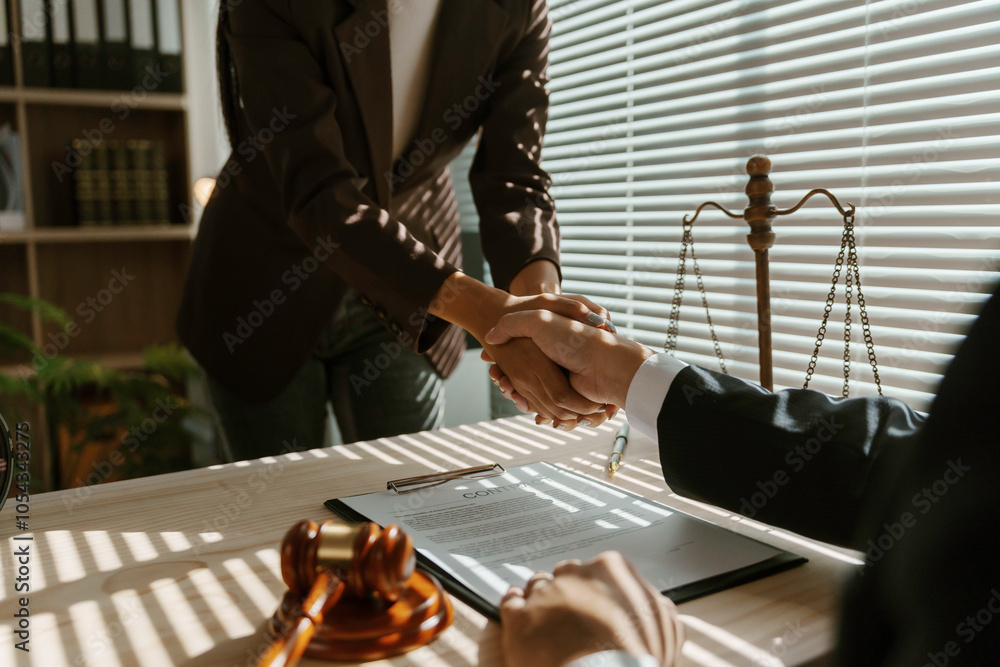 Lawyers shaking hands after signing a contract with a gavel and scales ...