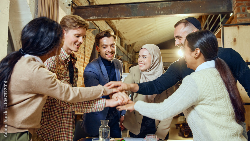 Multicultural team in open, relaxed office setting celebrates unity by ...