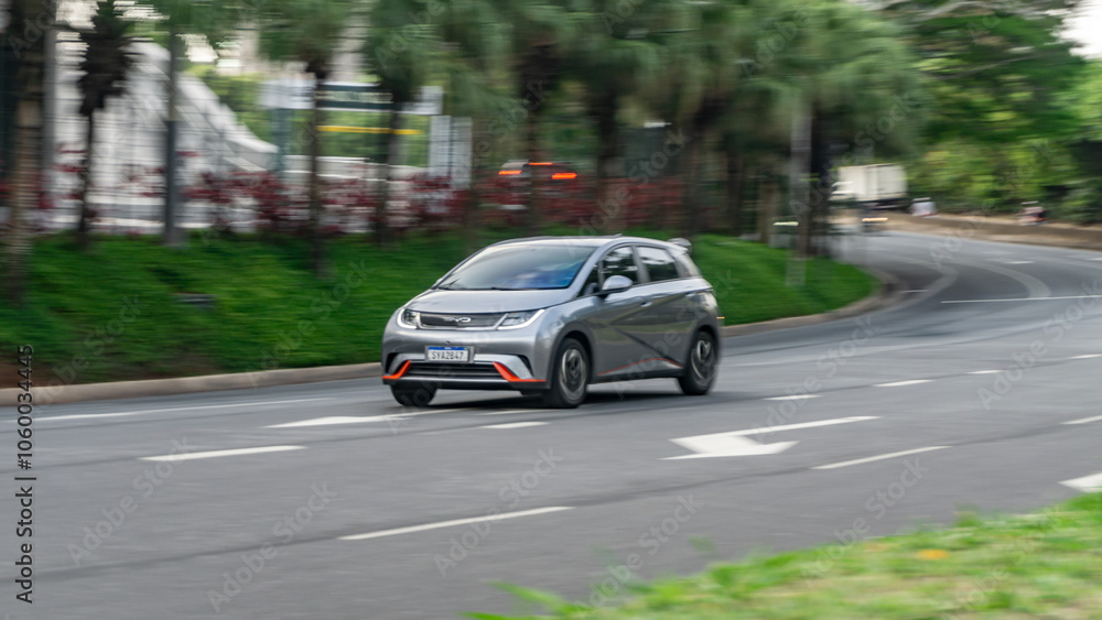 Grey BYD Dolphin in city traffic, Compact electric car in movement ...
