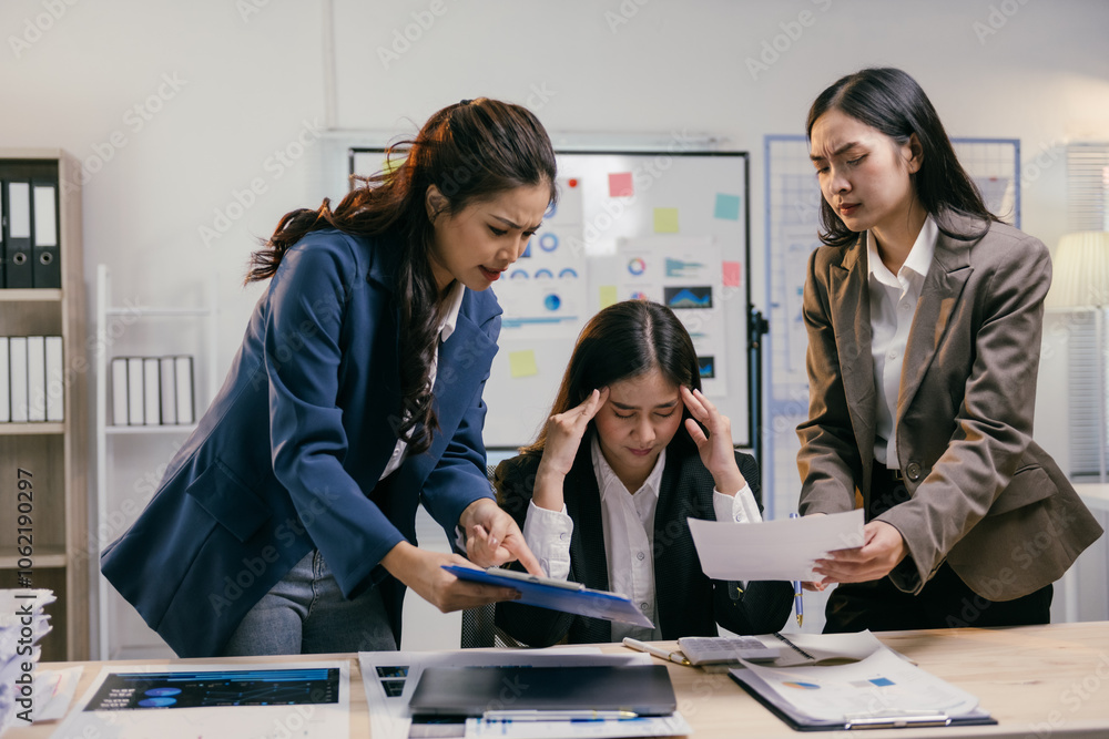 Stressed asian businesswomen having dispute over paperwork showing bad ...