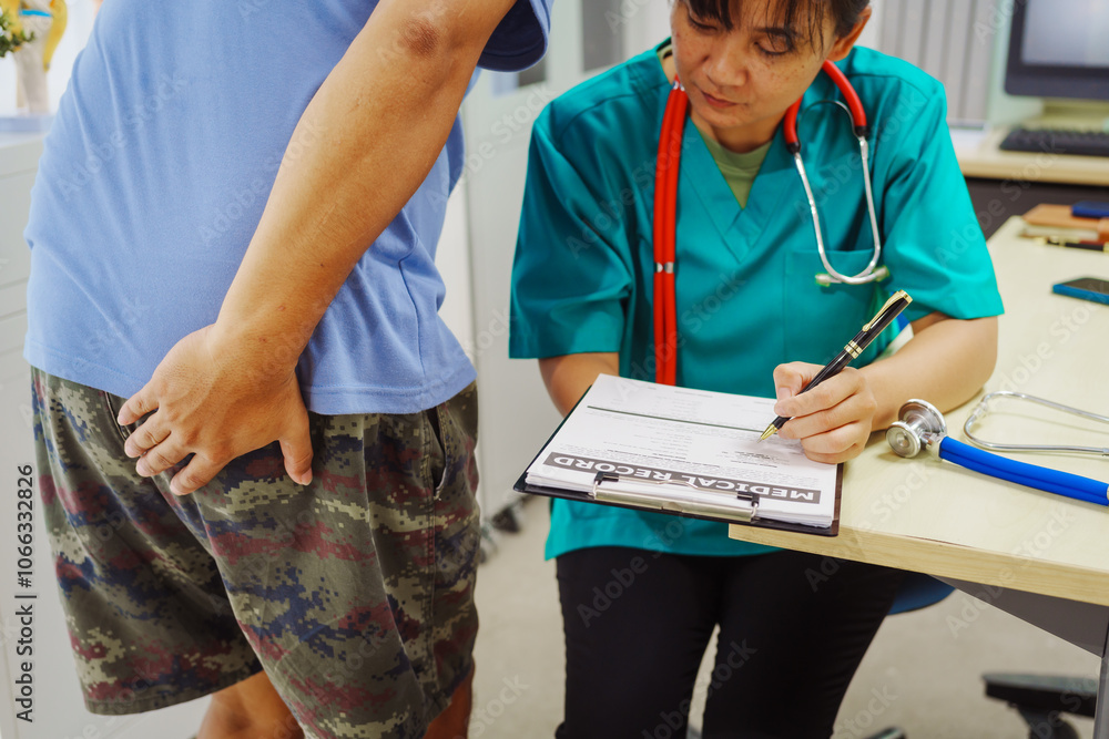 A female doctor sits a hospital desk,examining a sick male patient with ...