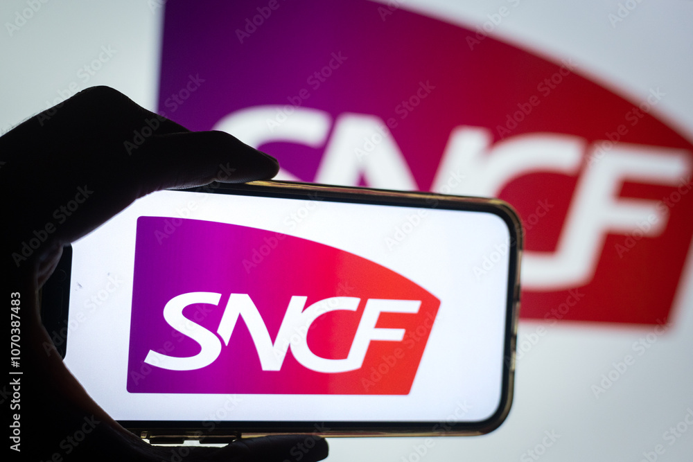 Silhouette of Hand Holding Phone with SNCF (SNCF) Logo in Front of ...