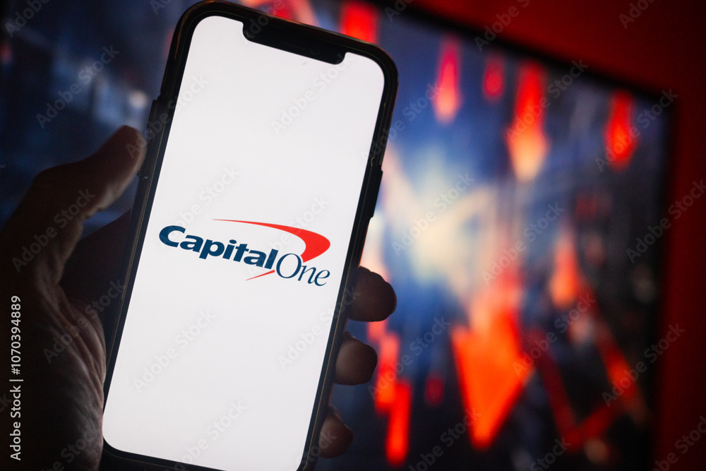 Hand Holding Phone with Capital One (COF) Logo and Monitor in the ...