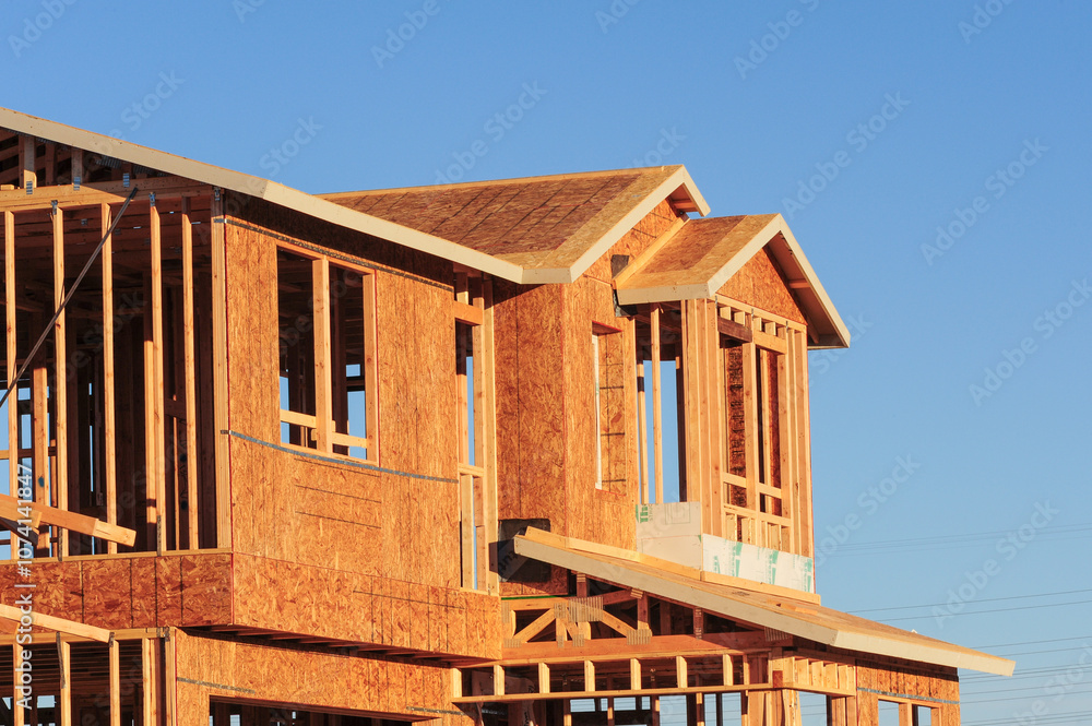 Close-up of two wood-frame houses under construction, featuring ...