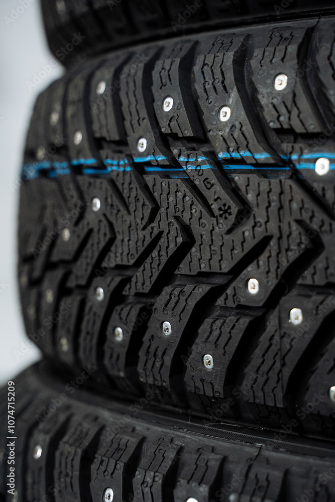 This image features a closeup view of a stack of automotive tires that ...