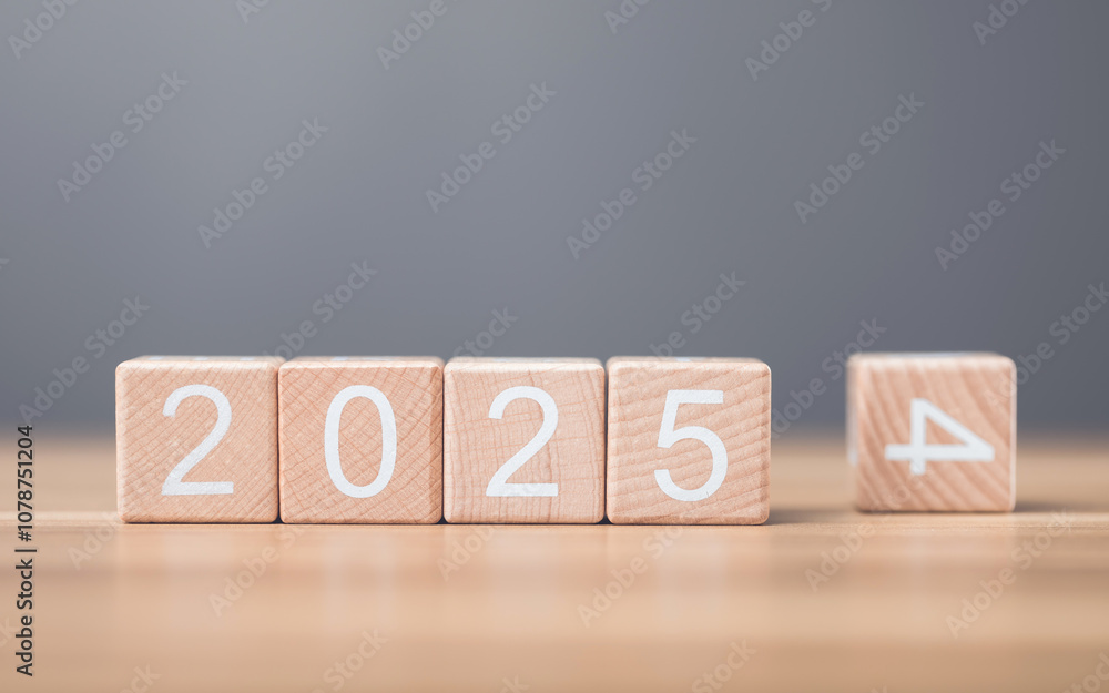 Hand replaces "2024" with "2025" using number blocks, symbolizing the ...