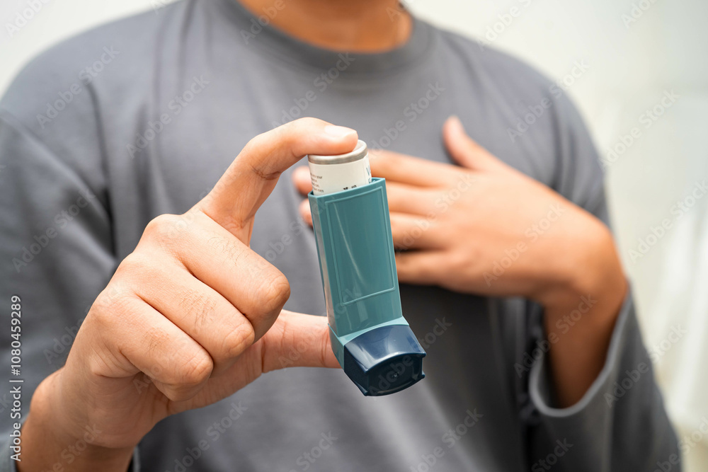 Asthma and chronic obstructive pulmonary disease COPD, Asian young man using metered dose ...