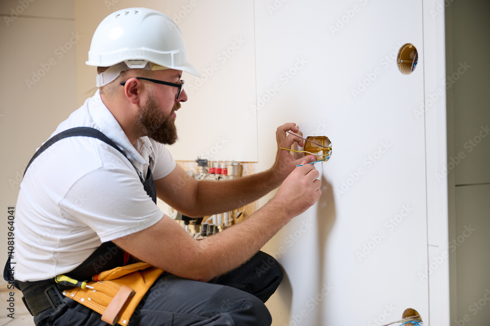 Builder installing electric socket in new apartment. Installing ...