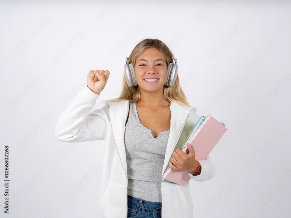 Beautiful teen girl wearing white jacket pointing up with fingers ...