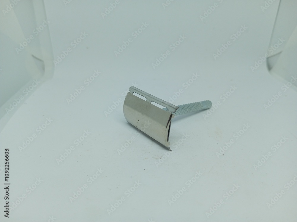 A classic silver safety razor displayed on a clean white background ...