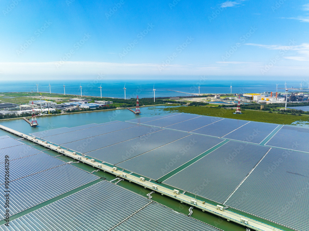 An aerial view shows a solar power plant floating on calm water, with rows of solar panels ...