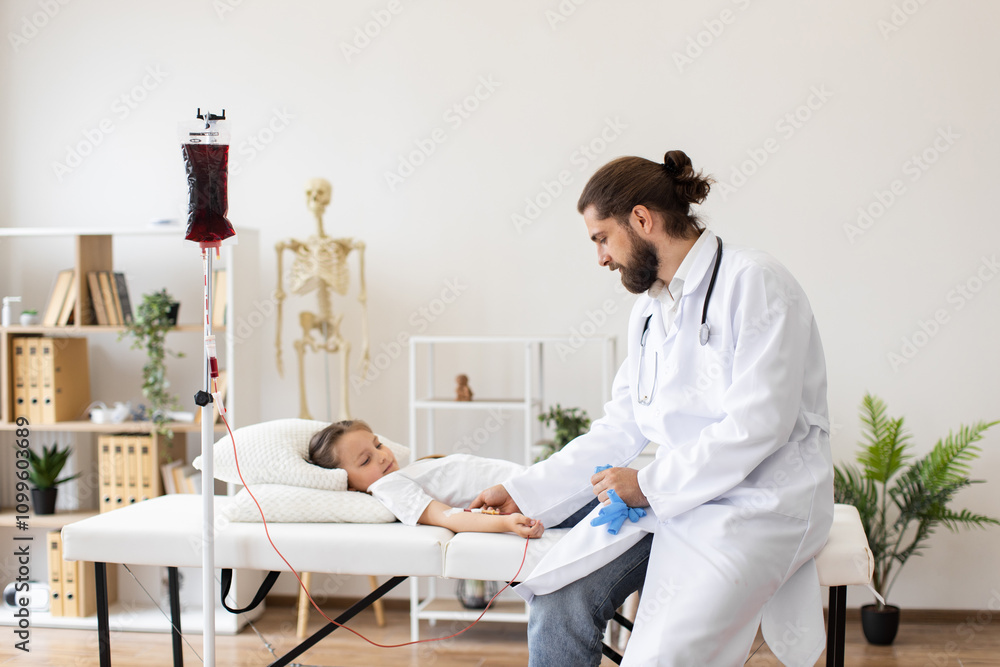 Male doctor gives blood transfusion to young girl at clinic. Scene ...