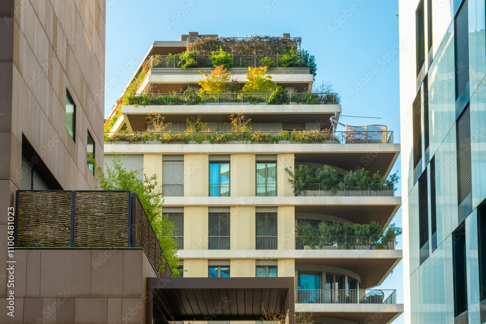 Contemporary building with greenery covered terraces with modern urban ...