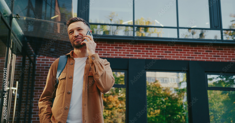Caucasian man entering from modern building. Answering important call ...