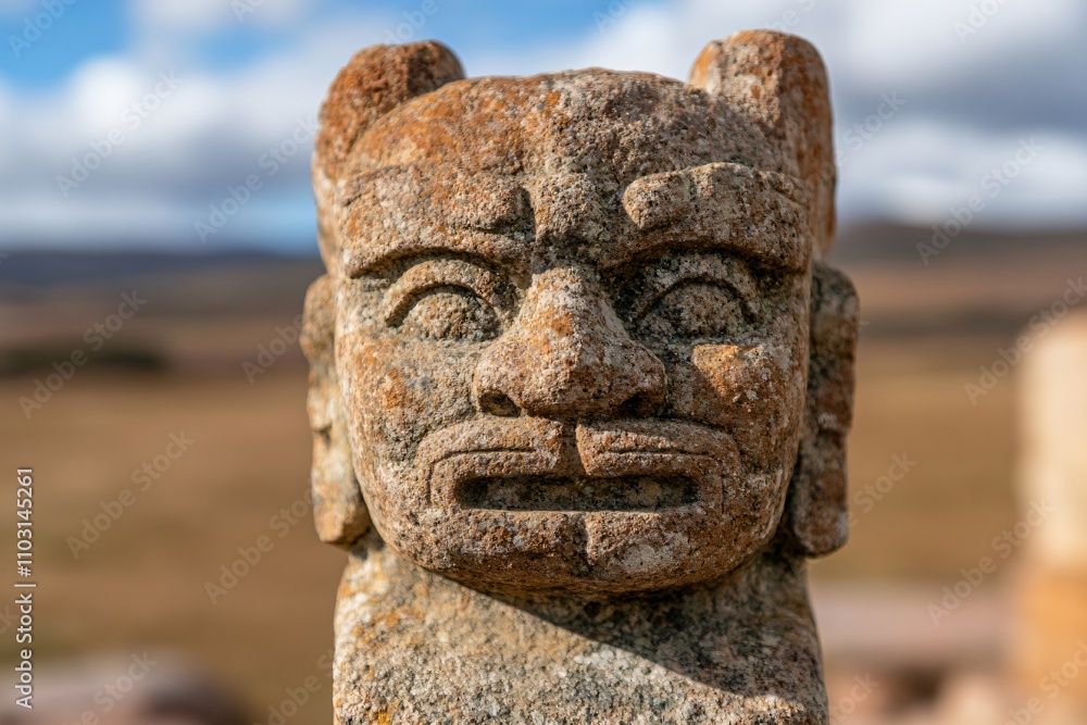 Ancient stone totem statue with animal ears against blurred nature ...
