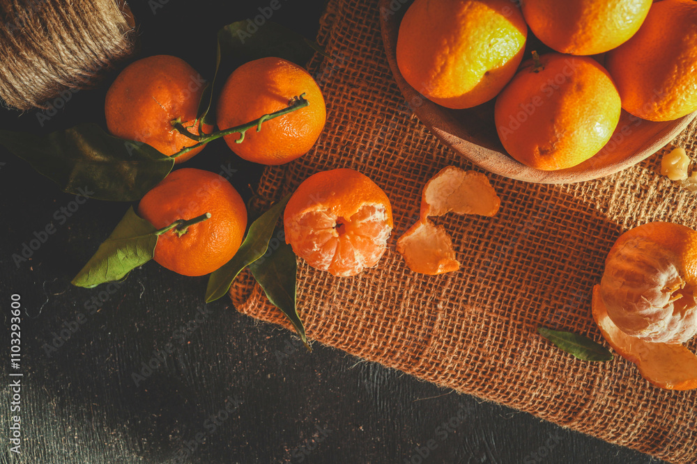 Rustic still life of peeled and whole tangerines on a burlap background ...