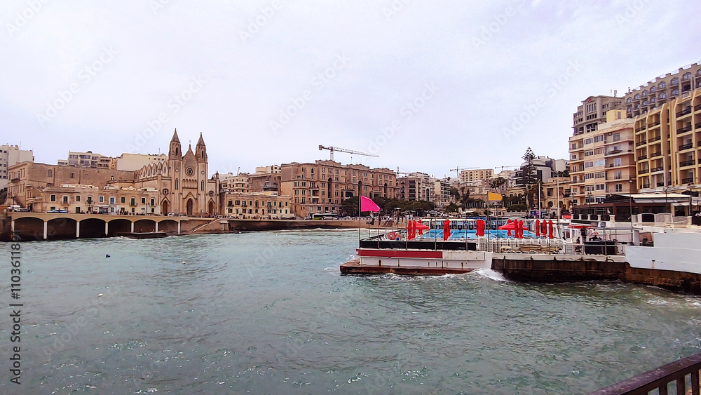 Promenade and pier of Balluta Bay in the town of St. Julian's, Malta ...