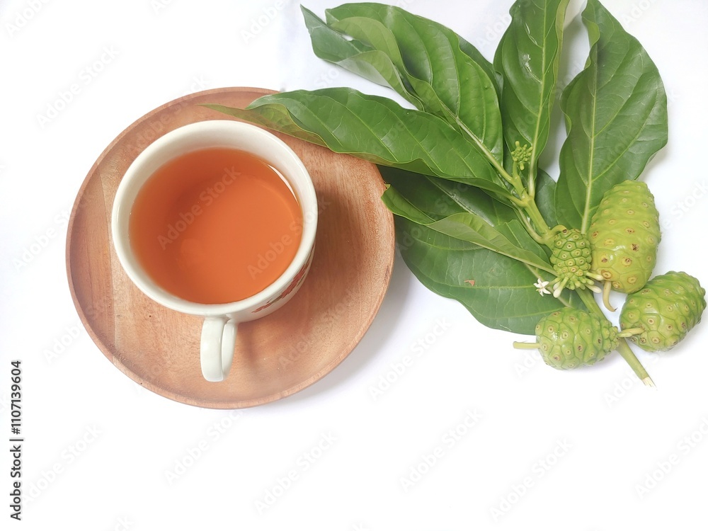 Noni fruit or Morinda citrifolia (Indian mulberry) with green leaves on ...