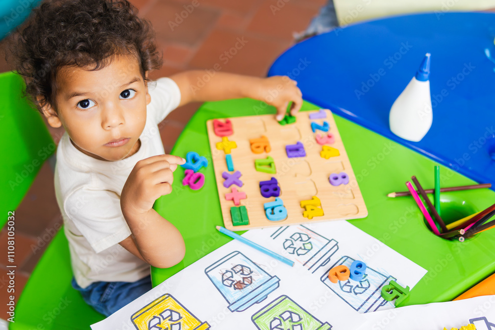 Latino boy learning math with wooden educational numbers, looking at ...