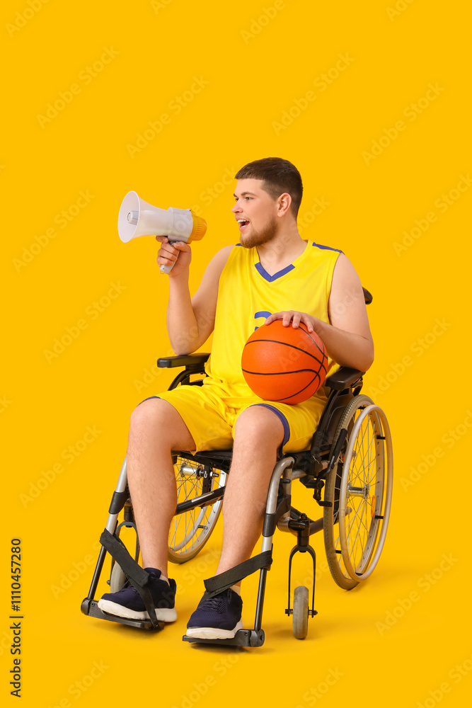 Male basketball player in wheelchair shouting into megaphone on yellow ...