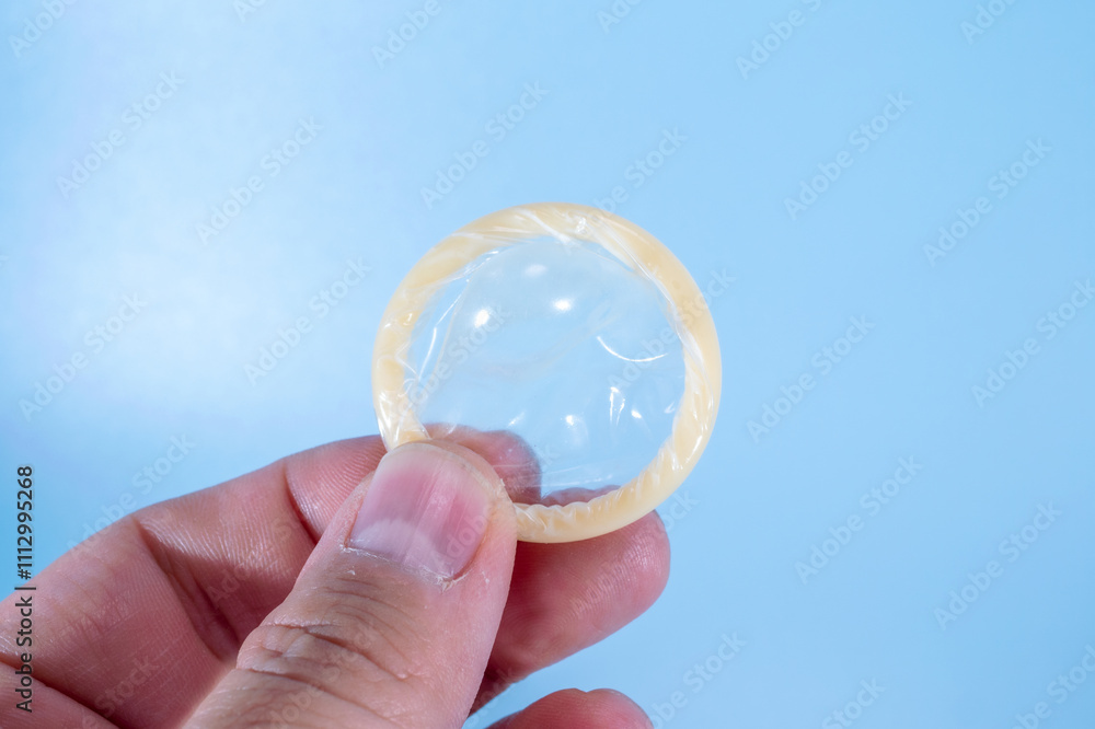 Image of a rolled-up condom on a blue background. Using a condom ...