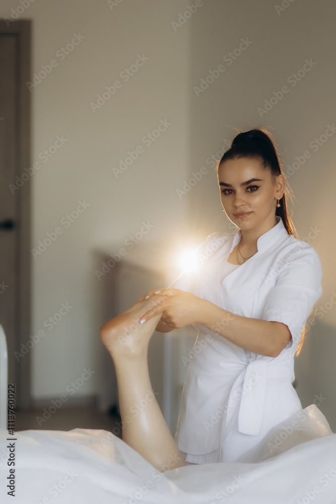 Massage therapist presses on the acupuncture points on female feet in ...