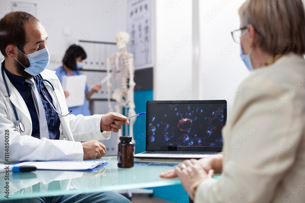 Masked doctor showing visual representation of flu virus to senior ...