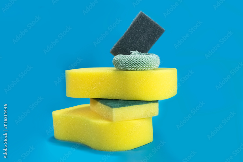 Many pieces of yellow washing sponges are stacked on a beautiful blue ...