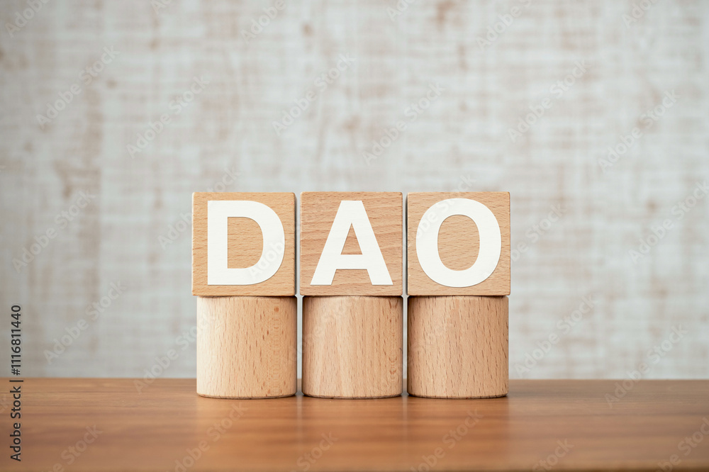 There is wood cube with the word DAO. It is an abbreviation for Decentralized Autonomous ...