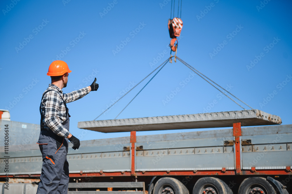 Construction site crane is lifting a precast concrete wall panel to ...