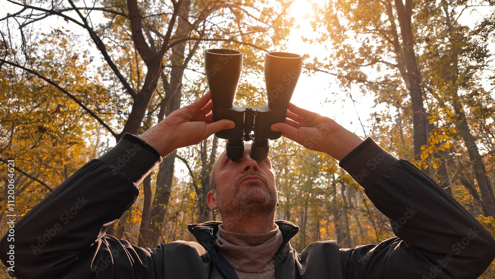 Amateur birdwatcher observing birds and other animals in nature with ...