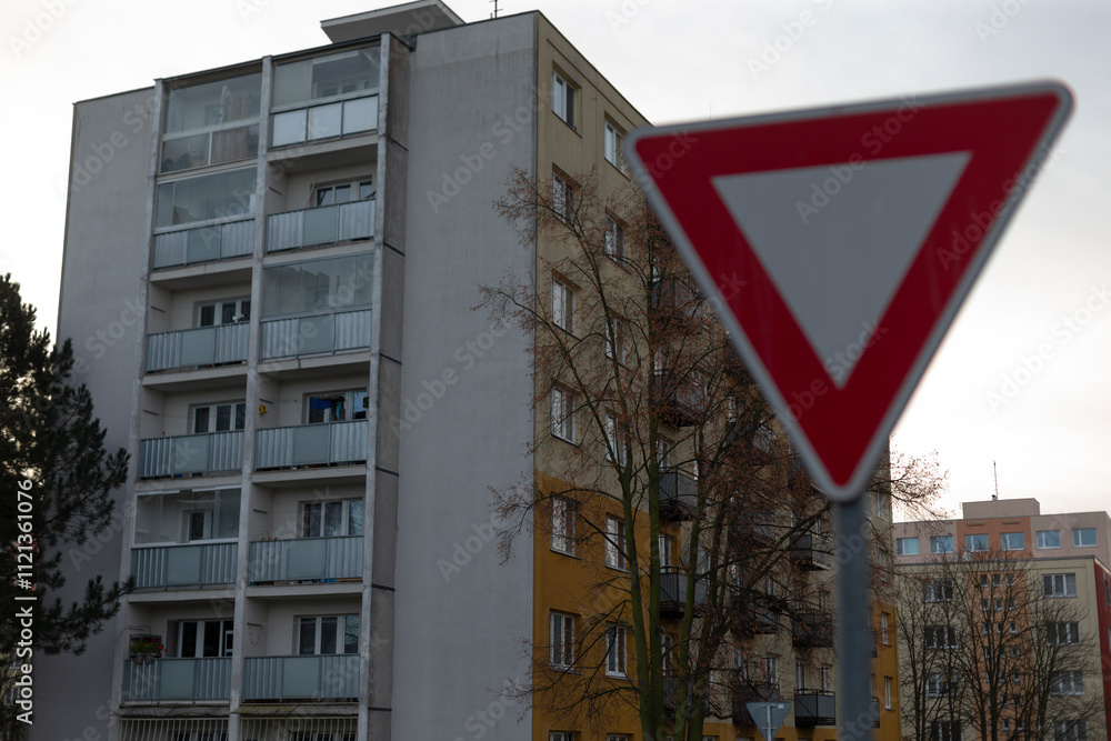 In front of a tall building, there is a prominent red and white ...