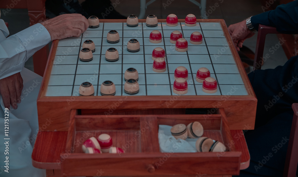 Traditional Qatari men playing Dama board game in Katara beach close up ...