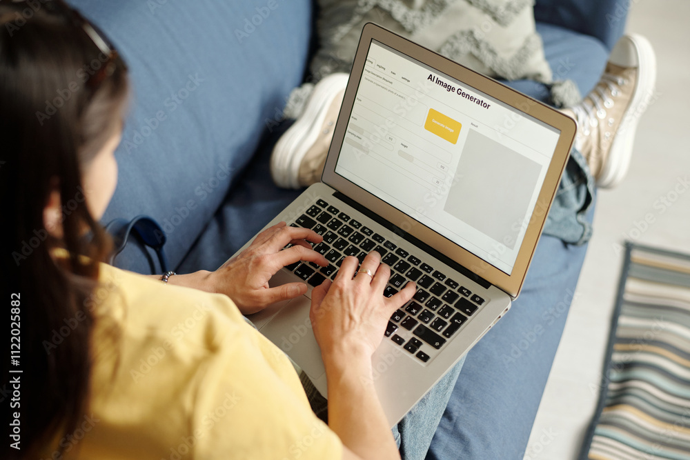 High angle of young woman in jeans and t-shirt touching keys of computer keypad during work with ...