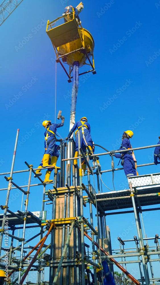 Workers using a hoist to lift concrete for a column pour. Lifting ...
