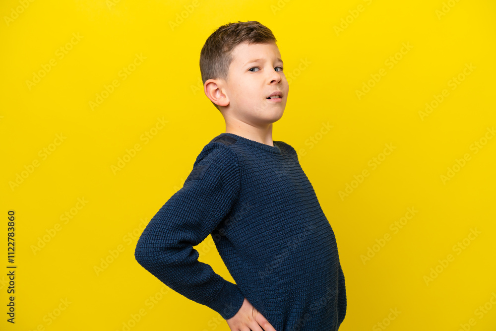 Little caucasian boy isolated on yellow background suffering from ...