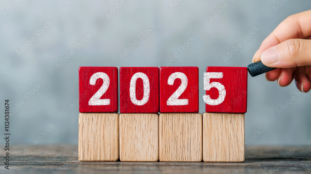 New Year 2025 with Wooden Blocks concept. Hand placing block numbers to ...