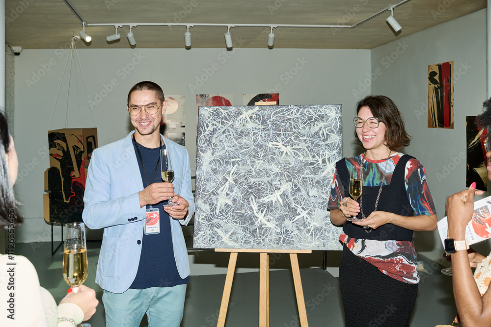 Young laughing male and female presenters of new artwork standing in ...