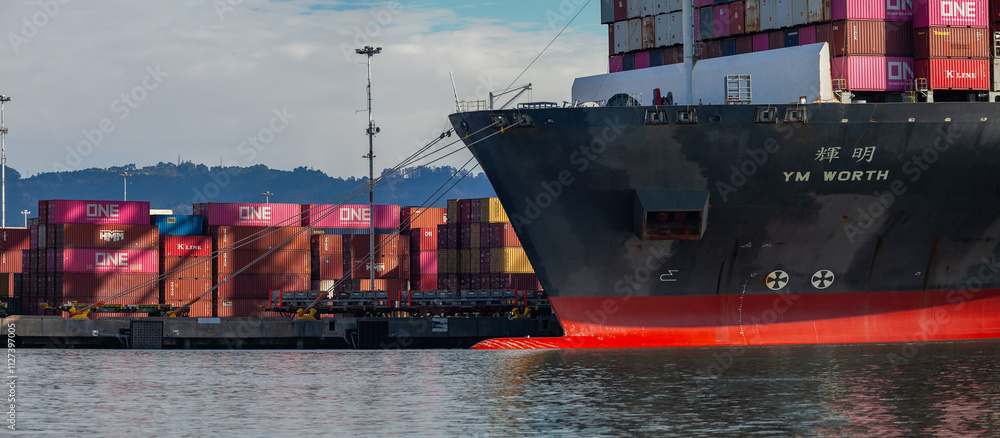 A cargo ship docked at the Port of Oakland, with shipping containers ...