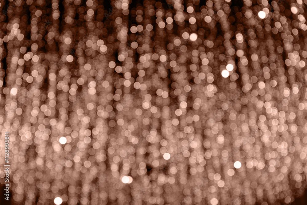 Defocused glittering background of golden garland lights on city street. Abstract blurry bokeh ...