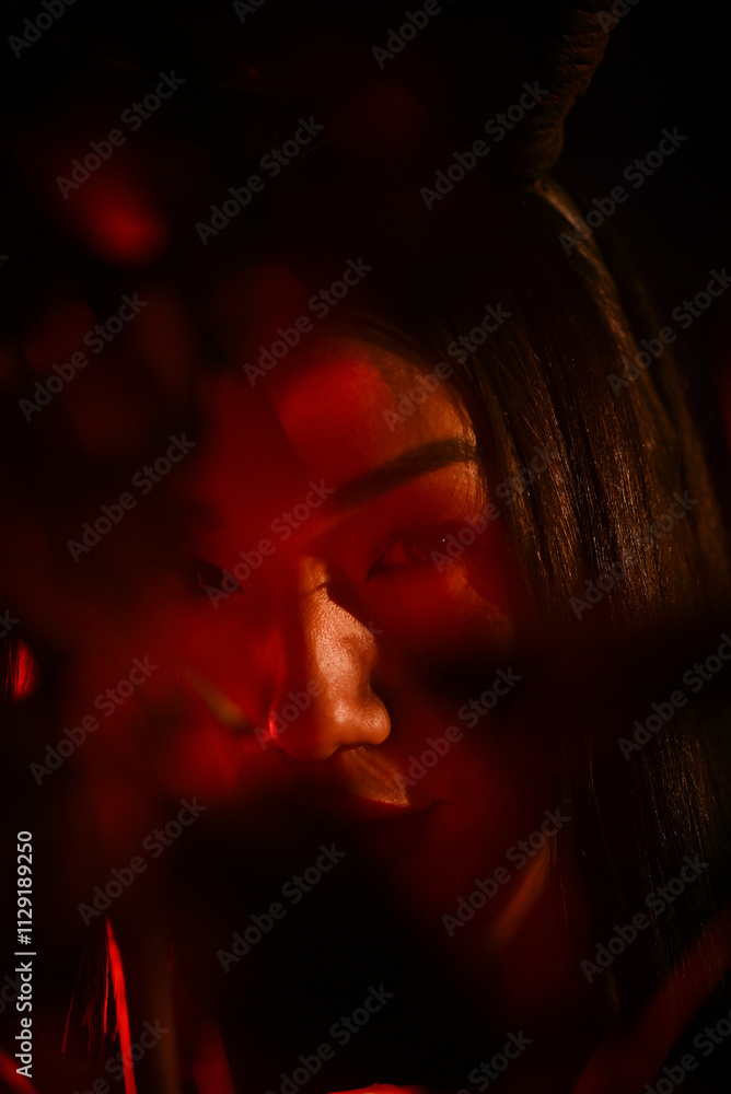 Beautiful asian woman a demon with evil horns posing on a dark ...