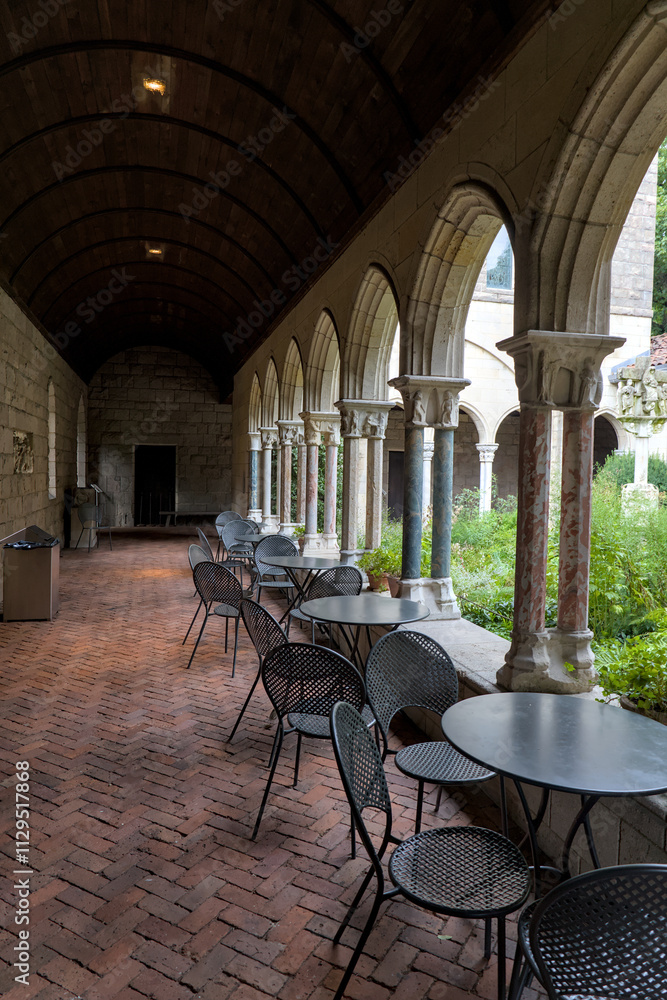 black metal outdoor restaurant tables and chairs in arched garden with ...