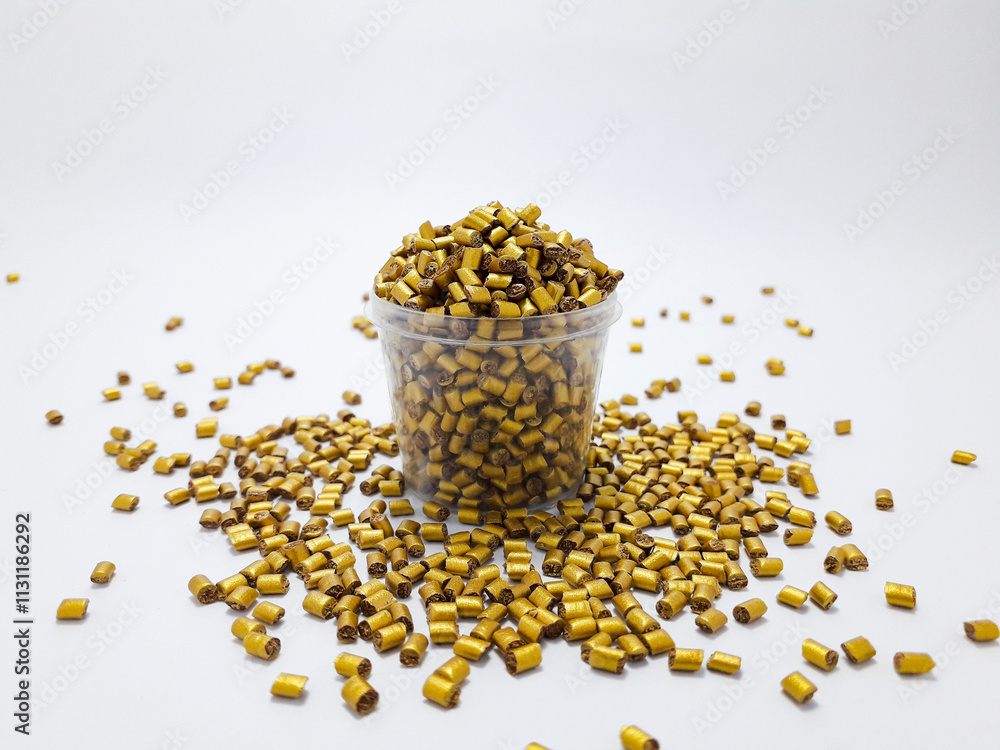 Gold color masterbatch granules in cup and isolated on white background ...