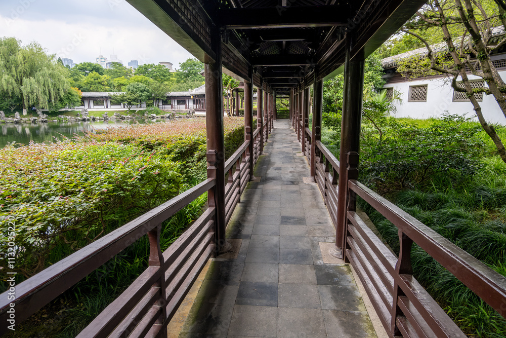 Wooden covered walkway connecting pavilions leading through a ...
