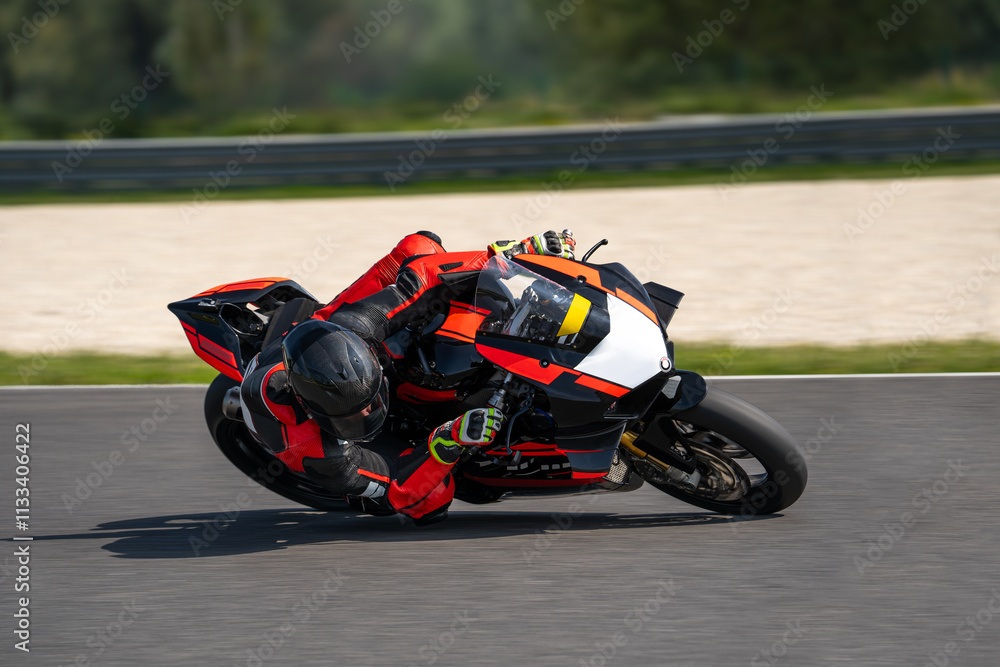 Rider on a red sport motorcycle riding fast through a corner and ...