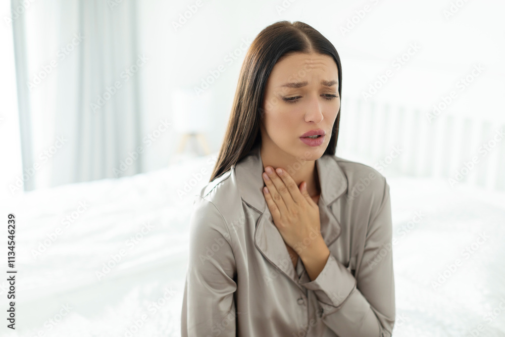 Sad sick woman coughing, touching neck with hand, suffering from sore ...