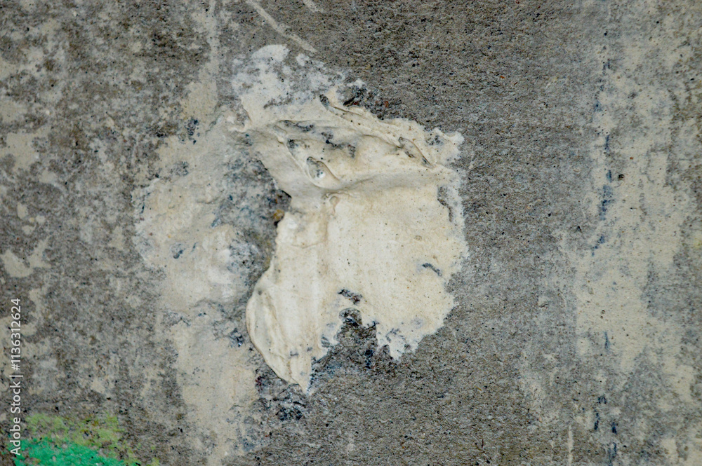 close-up rough aged wall with patches of peeling paint and faded ...