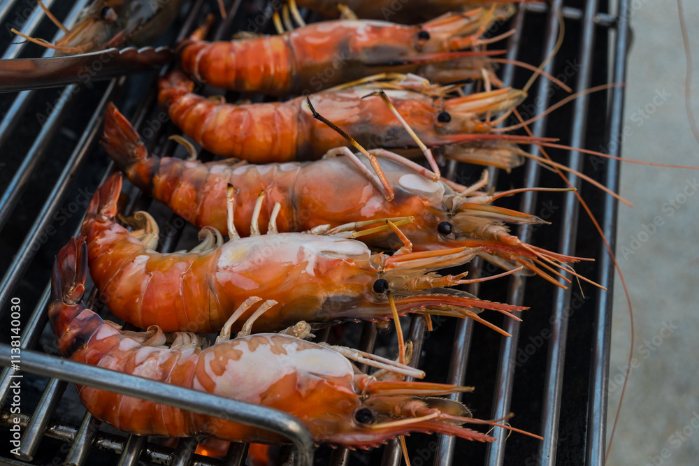 Thai river prawns grilled on the iron rack over the charcoal grill that ...