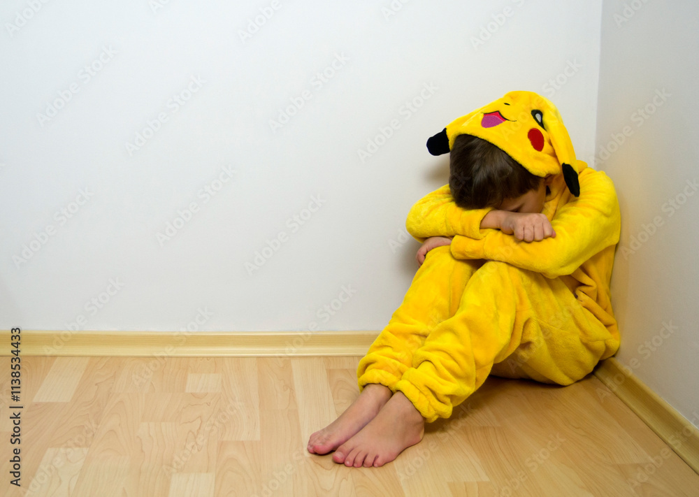 Little boy crying with her head down.The child is sitting sad scared on ...