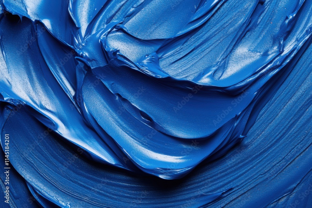 Vibrant blue paint showing texture and movement on a canvas surface in ...